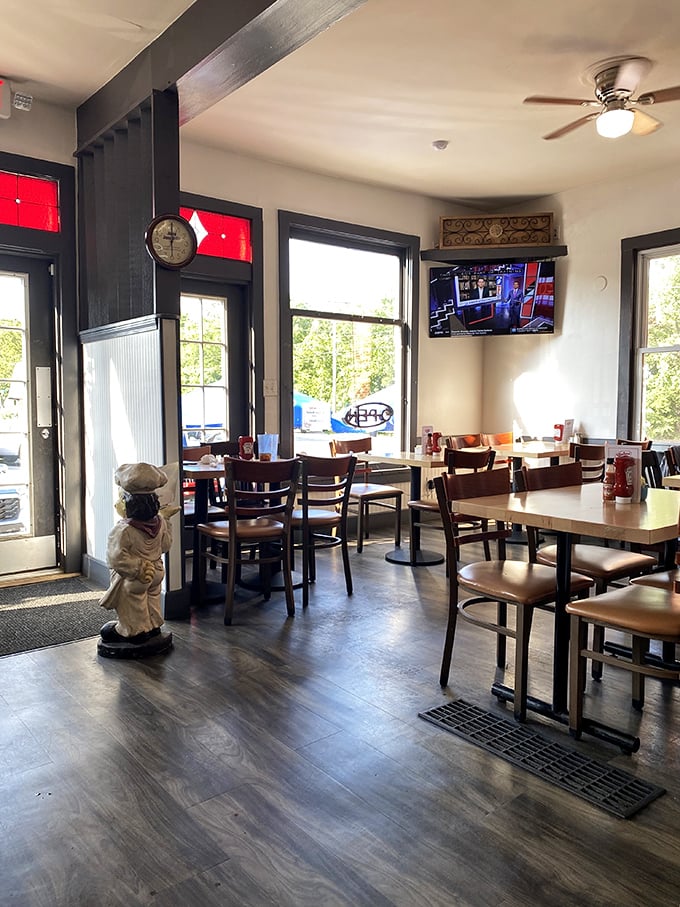 Wooden tables, natural light, and a chef statue standing guard—this dining room feels like the living room of your coolest friend.