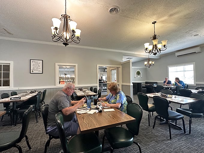 Elegant chandeliers cast a warm glow over simple wooden tables, creating a dining room that says, "Stay awhile, we've got pie."