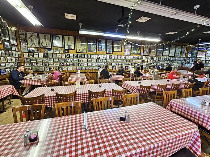 The dining room wall—plastered with decades of photographs—serves as both decoration and proof that you're eating somewhere that matters.