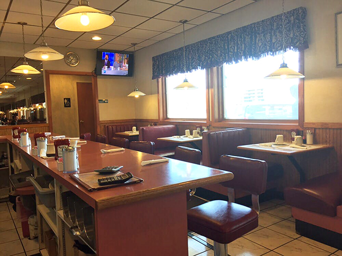 The counter seating area—where solo diners become regulars, and servers remember your coffee preferences better than your own children do.