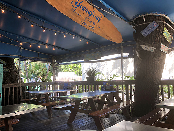 Dining under string lights with a surfboard overhead—this outdoor seating area captures the essence of casual Florida dining perfection.