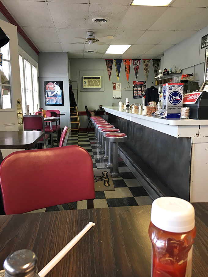 Red vinyl stools lined up like loyal soldiers, ready to support the weight of both hungry diners and their post-breakfast contentment.