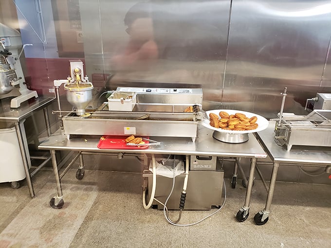 Where the magic happens! Fresh donuts emerging from their hot oil bath, ready to be transformed into your personal dream dessert.