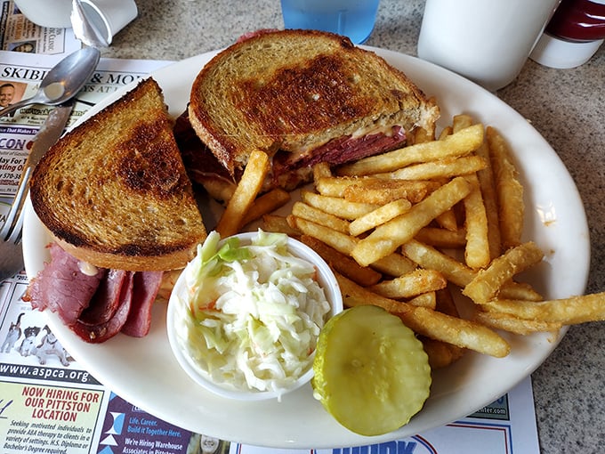 The holy trinity of diner perfection: a grilled cheese sandwich, crispy fries, and that pickle spear standing guard like it owns the plate.