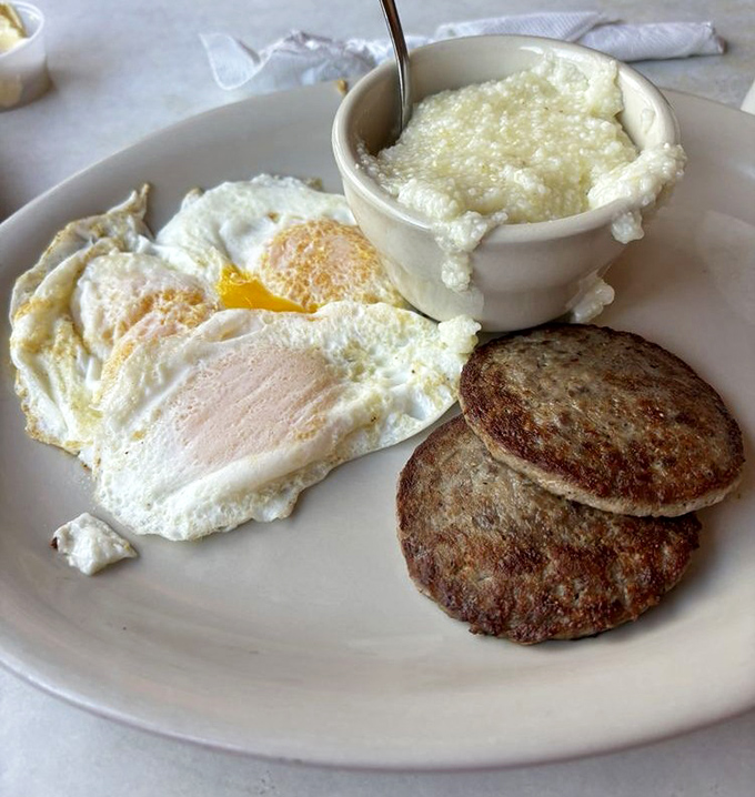 Two eggs sunny-side up with a side of sausage patties—proof that sometimes the simplest combinations create the most profound happiness.