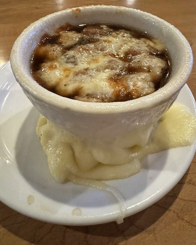 French onion soup with a cheese cap so perfect it deserves its own superhero cape. The mashed potatoes below are the sidekick we all need.