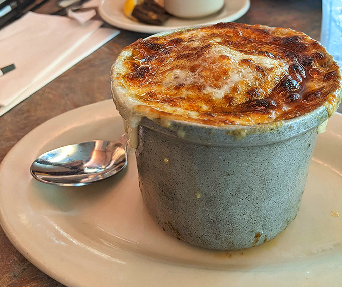 French onion soup wearing its cheese cap with pride—a bubbling cauldron of comfort that's worth every moment of the inevitable cheese pull.