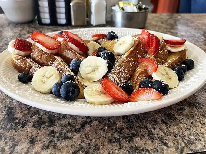 French toast that makes you question why you ever settled for regular toast. Those berries and bananas aren't garnish—they're supporting actors in breakfast theater.