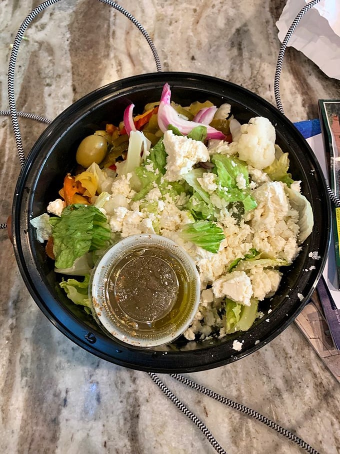 A Greek salad that actually looks like someone cared when they made it—fresh, vibrant, and a noble attempt at balancing out the pizza.