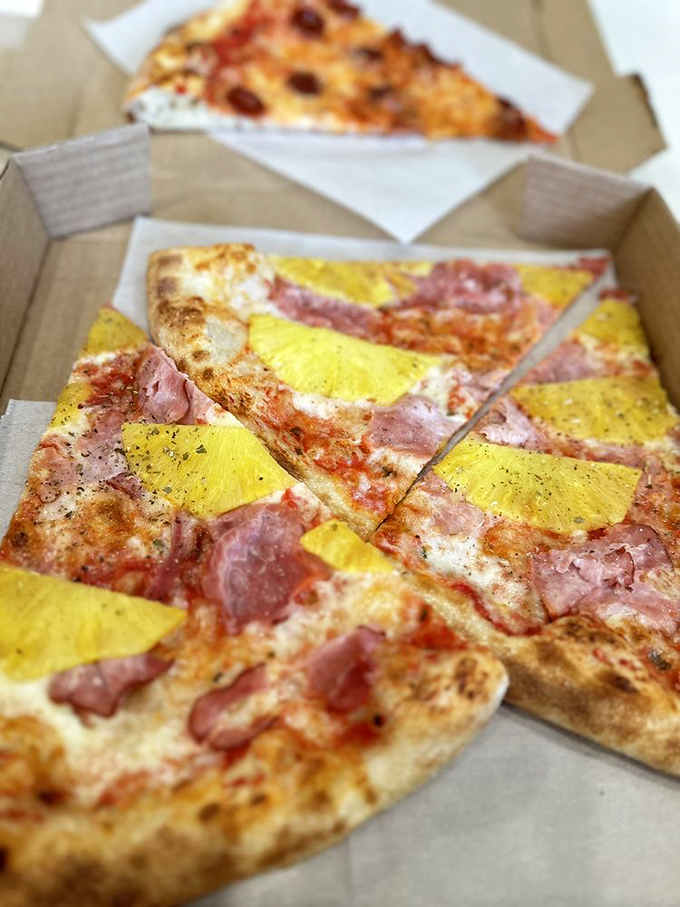 The controversial Hawaiian—yellow pineapple squares and ham creating a sweet-savory debate on a pizza canvas. Even purists might be converted here.