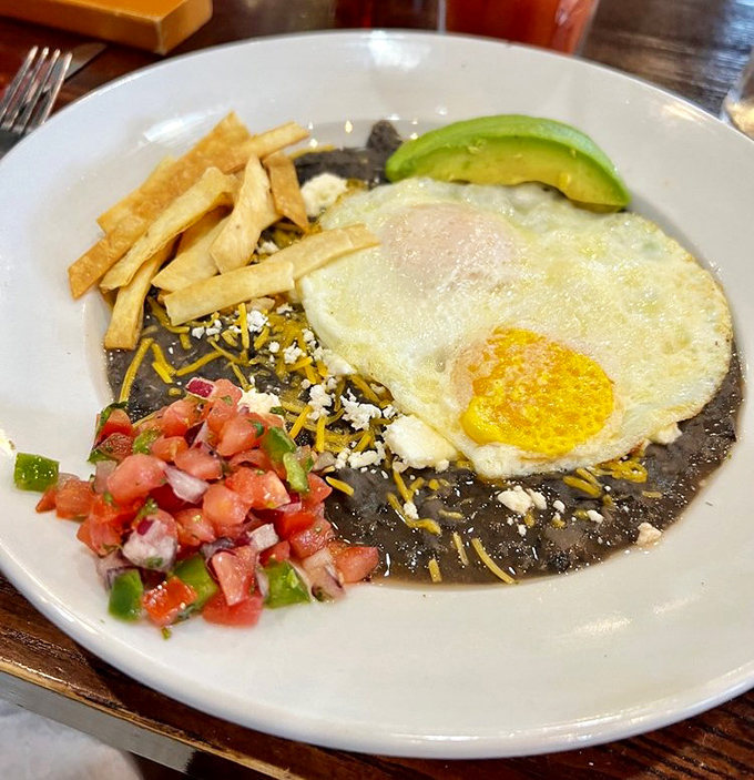 Huevos Rancheros bringing the fiesta to your morning. Black beans, fresh pico, and that perfectly fried egg—a breakfast worth crossing borders for.