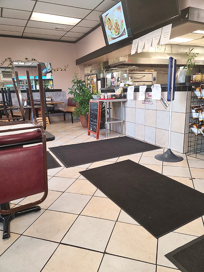 The ordering counter—where dreams become reality. Black floor mats mark the path to pizza paradise like a casual red carpet.