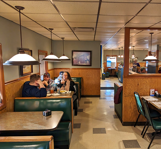 Green booths and wood paneling create that timeless diner atmosphere where conversations flow as freely as the coffee. Some design trends never need updating.
