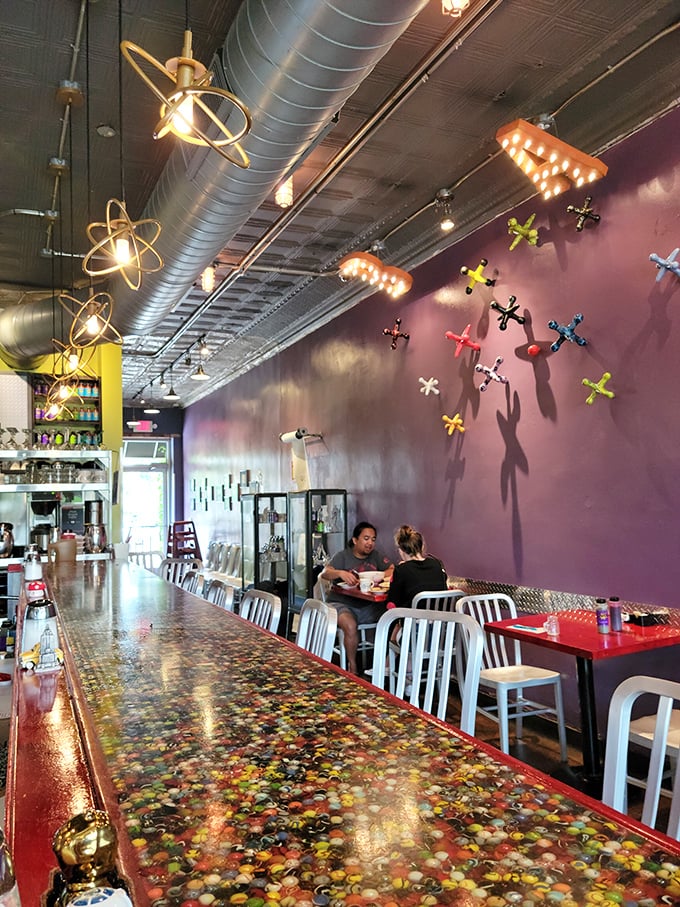 Purple walls set the stage while atomic light fixtures dangle overhead—this isn't just decor, it's conversation fodder between bites.