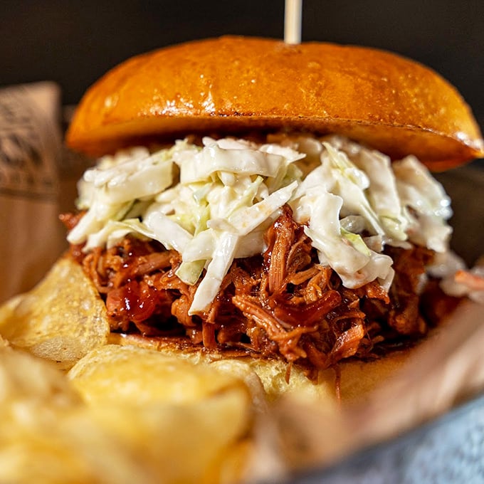 This pulled pork sandwich isn't just comfort food—it's a hug on a bun with coleslaw standing by for moral support.