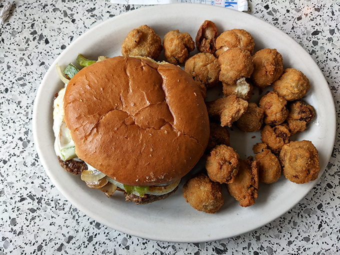 A burger that requires a game plan before the first bite, flanked by golden mushroom soldiers standing at attention, ready for their delicious duty.