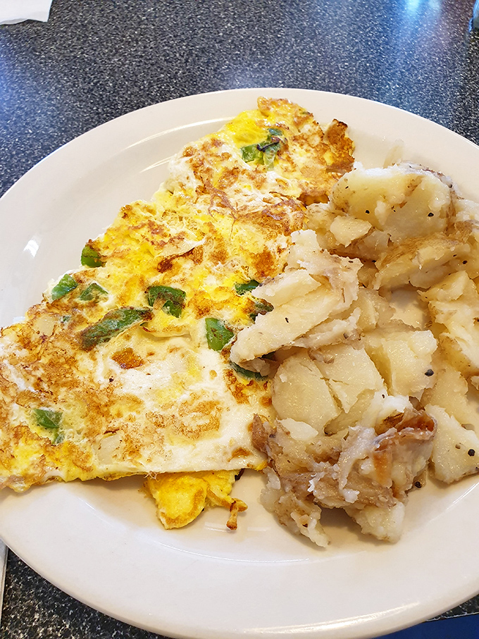 An omelet that knows its purpose in life: to be fluffy, filled with good things, and paired with home fries that could make a potato farmer weep.
