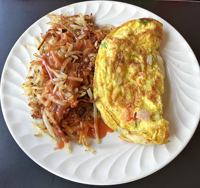 An omelet so perfectly executed it deserves its own Food Network special, with hash browns that crackle with each forkful.