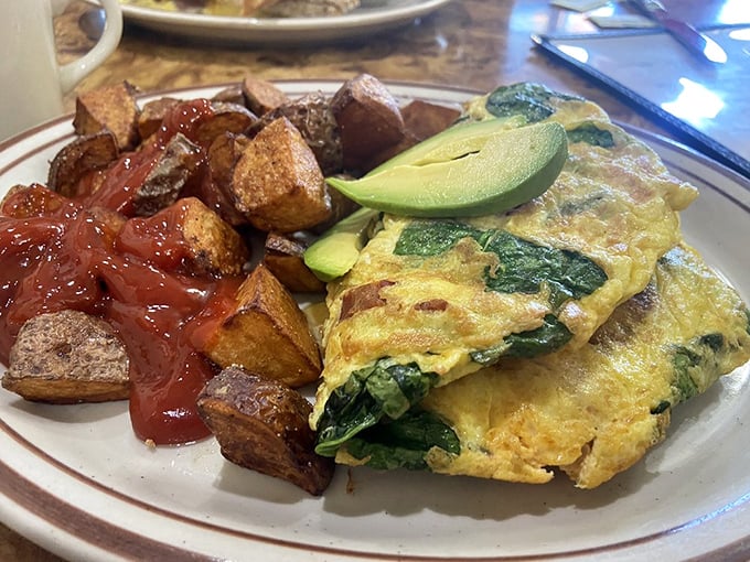 This isn't just an omelet – it's a masterclass in egg architecture, filled with spinach and paired with potatoes that achieved crispy perfection.