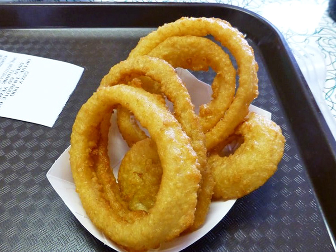 Onion rings with architectural integrity that would make Frank Lloyd Wright proud—crispy, substantial, and engineered for maximum flavor delivery.