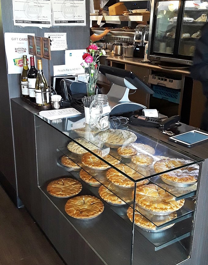 The pie display case—where willpower goes to die and happiness begins. Each golden crust promises a different slice of heaven.
