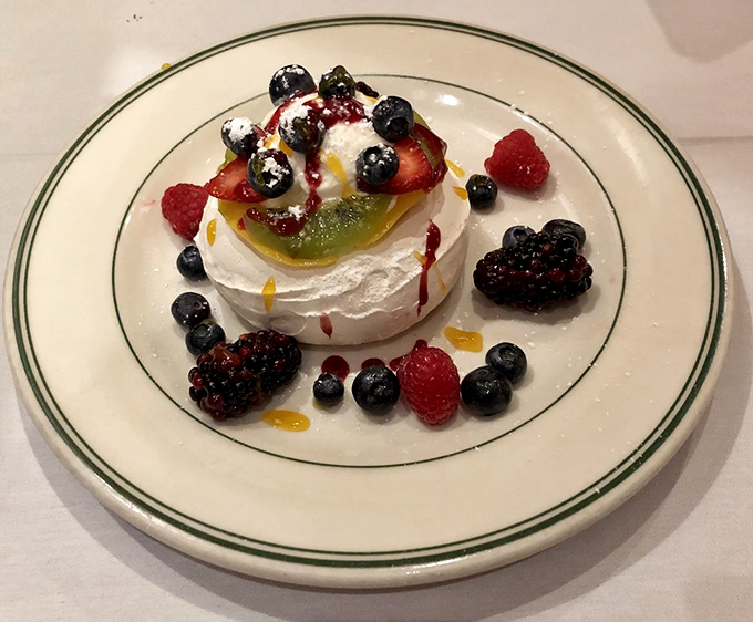The Pavlova arrives like a ballerina on your plate – delicate, beautiful, and absolutely impossible to resist taking pictures of.