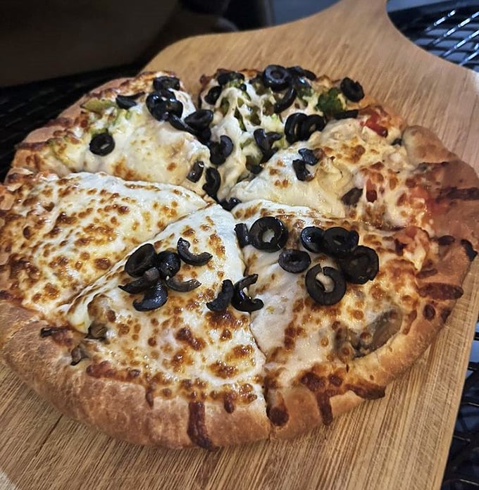 This isn't artisanal wood-fired pizza with imported buffalo milk cheese—it's honest, melty, olive-topped comfort on a perfectly browned crust.