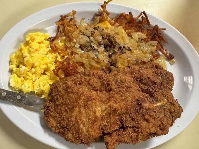 Country-fried pork chops with hash browns and eggs—the breakfast equivalent of a warm hug from someone who really knows how to cook.