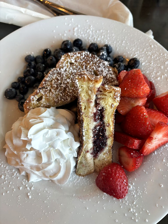French toast with a surprise filling—like finding hidden treasure. The whipped cream and fresh berries are just showing off now.
