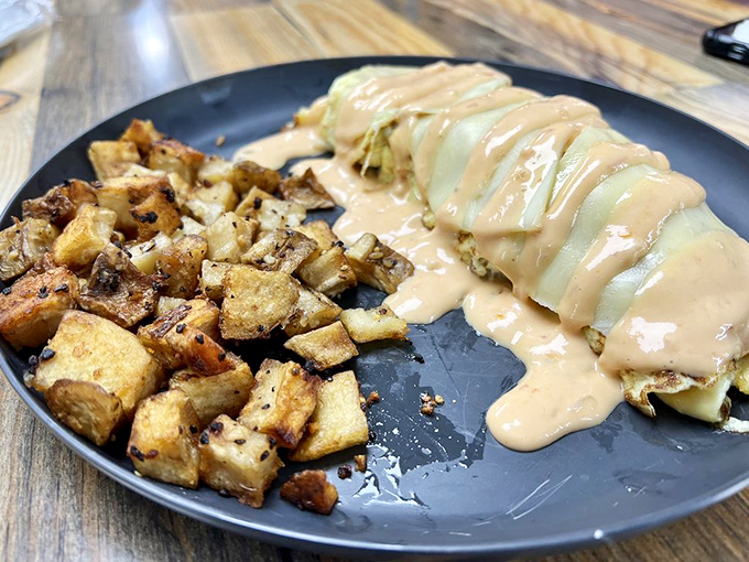 An omelette smothered in cheese sauce with perfectly seasoned potatoes on the side—breakfast's way of saying "I love you."