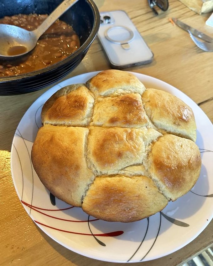 These golden-topped rolls aren't just bread—they're pillowy vessels of buttery goodness that somehow find room in your already-stretched stomach.