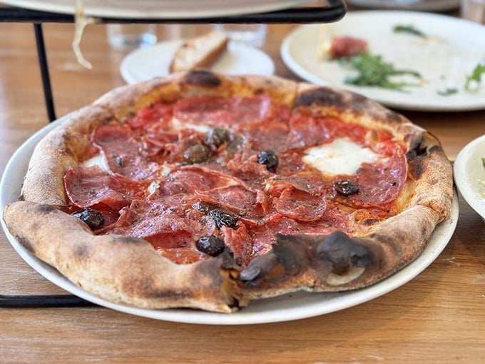 Meat lovers rejoice! This pizza doesn't just have toppings—it has personality, with salami and olives playing starring roles.