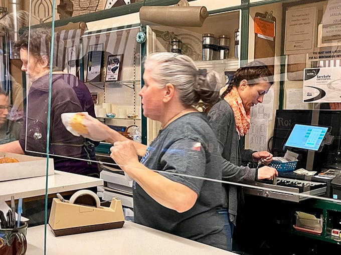 Behind the counter, the real magic happens as staff members orchestrate the daily donut ballet with practiced precision.