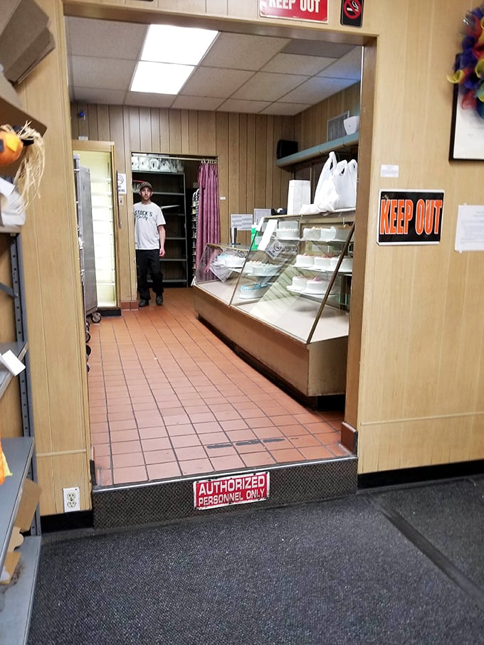 A glimpse behind the curtain reveals the no-nonsense bakery operation. That "KEEP OUT" sign means business – the cake business.