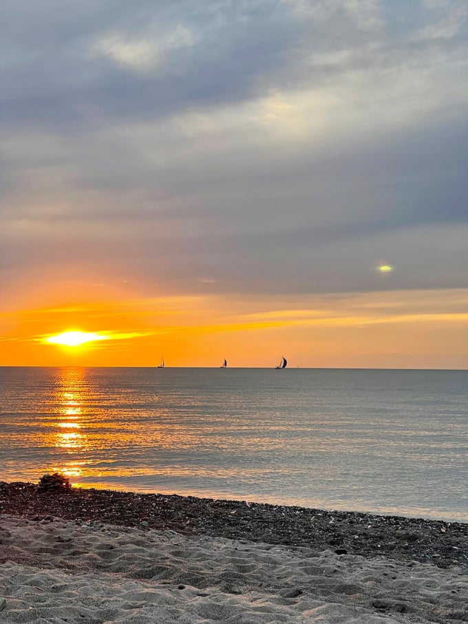 Sailboats drift through liquid gold as the sun performs its nightly farewell tour—no expensive cruise needed for this show.