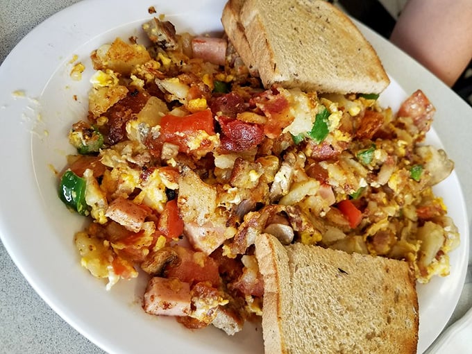 The Ultimate Herb Nelson—a glorious breakfast mountain where eggs, potatoes, and every breakfast meat imaginable collide in perfect harmony.