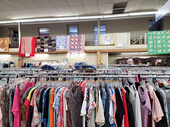 Clothing racks stretch to the horizon beneath handmade quilts. Fashion archaeology at its finest—dig deep enough and find vintage gold.