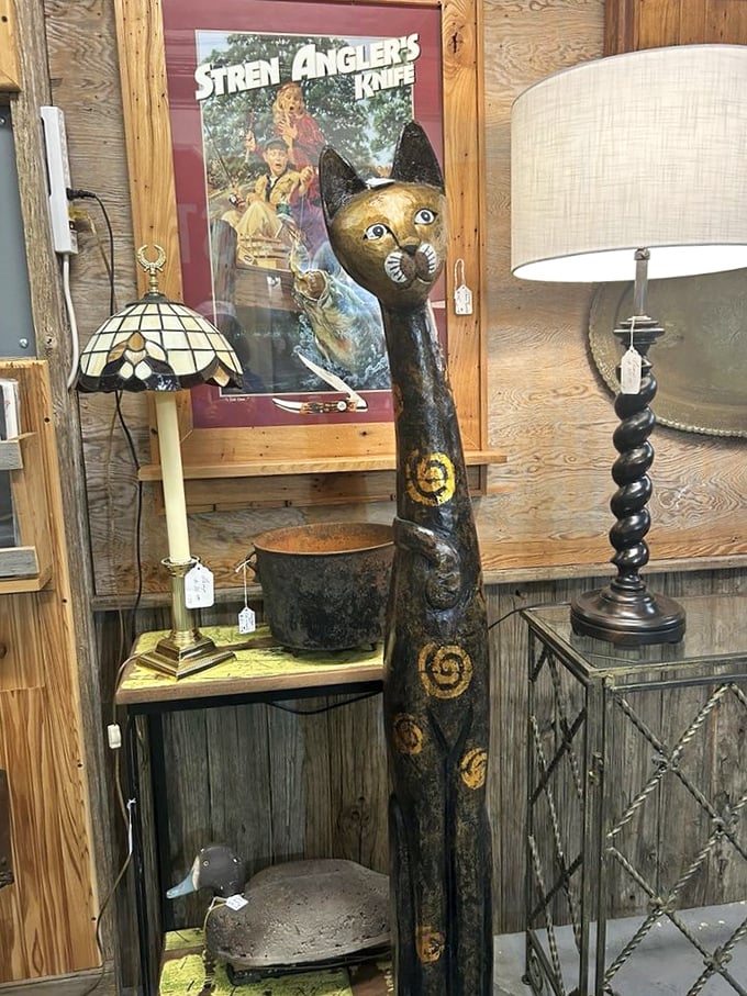 This elongated wooden cat statue isn't just decor—it's art with attitude, standing guard beside vintage lamps with timeless dignity.