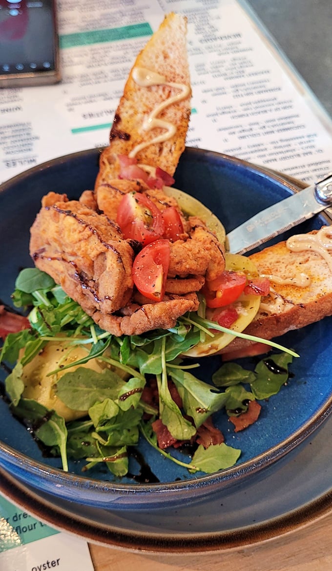 This isn't just fried seafood—it's an artistic statement. Crispy exterior giving way to tender fish, all resting on a bed of peppery arugula.