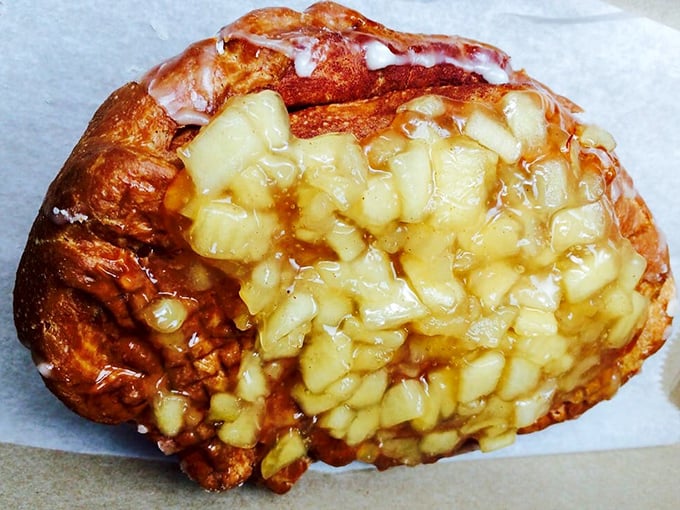 The apple fritter – a massive, irregularly-shaped wonder studded with cinnamon-spiced apple chunks that's more edible art than mere pastry.