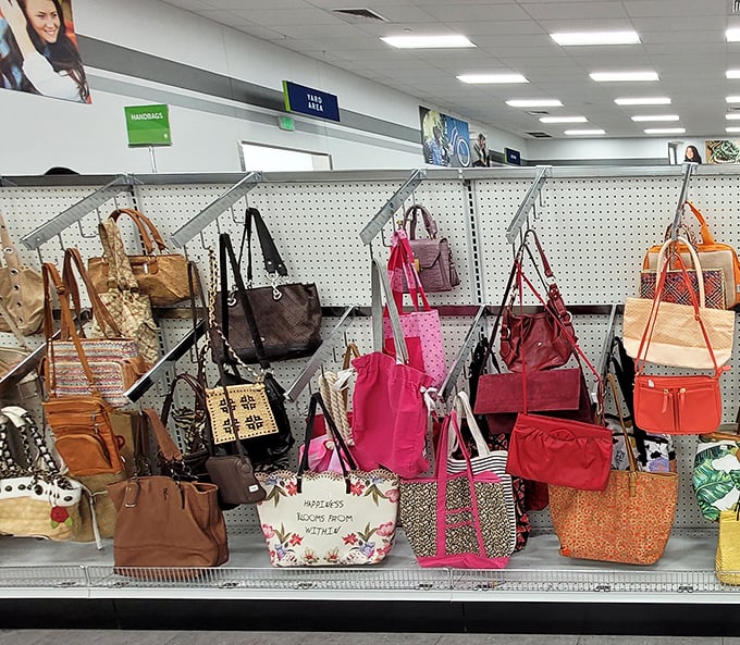 A rainbow of handbags hanging like art, each one ready to carry someone's dreams at a fraction of retail.
