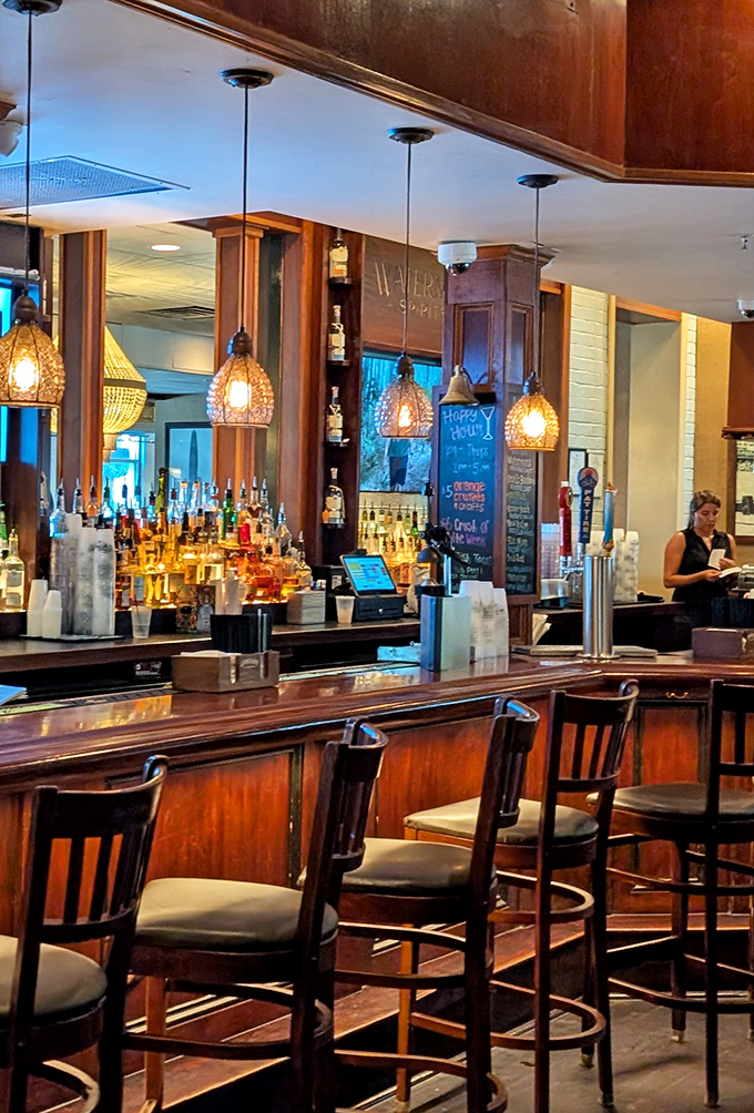 The bar at Waterman's glows with amber warmth, pendant lights casting a golden hue that makes everyone look like they're on vacation – even the locals.