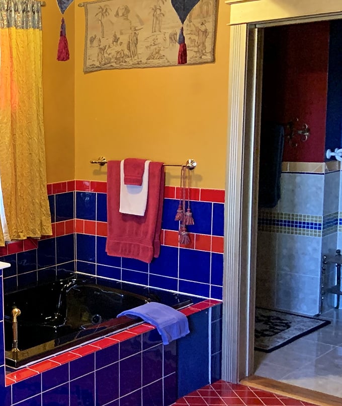 This bathroom's bold color scheme—royal blues and reds—transforms a functional space into something worthy of castle living.