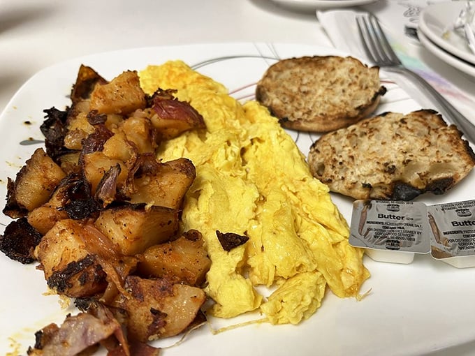The breakfast trinity: perfectly scrambled eggs, seasoned potatoes, and hearty toast. Simple perfection that reminds you why breakfast is the superior meal.