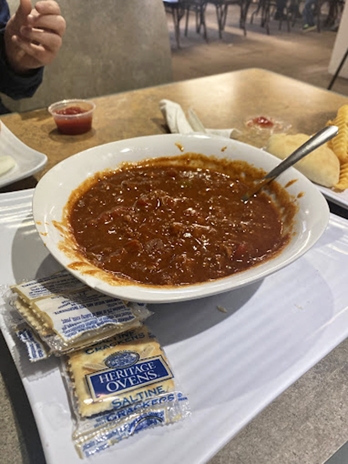 A bowl of hearty chili with crackers on the side—the kind of straightforward comfort food that makes you wonder why anyone bothers with complicated cuisine.
