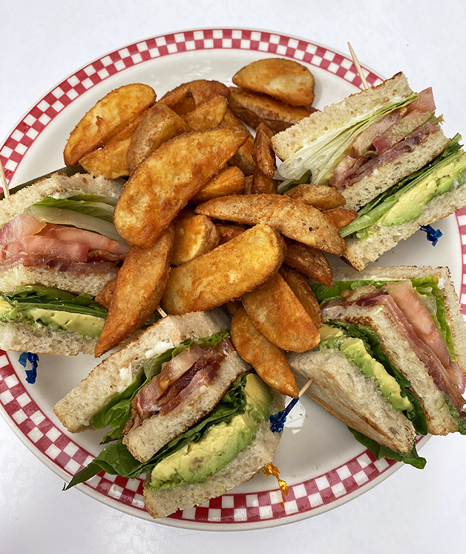 The club sandwich—architecture you can eat, with layers so perfectly balanced they could teach a master class in structural engineering.