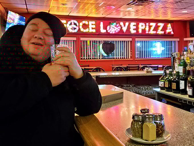 The bar area where strangers become friends and friends become family—all under the watchful glow of that iconic neon sign.