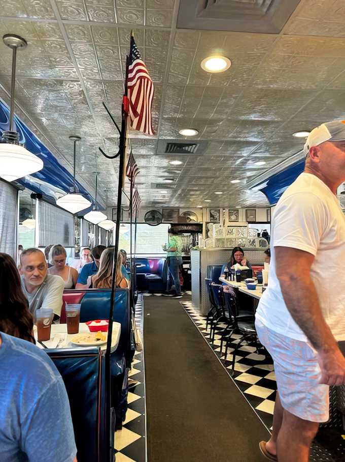 The classic diner aisle—where American flags stand proud, checkered floors gleam, and the buzz of conversation blends with the symphony of silverware on plates.