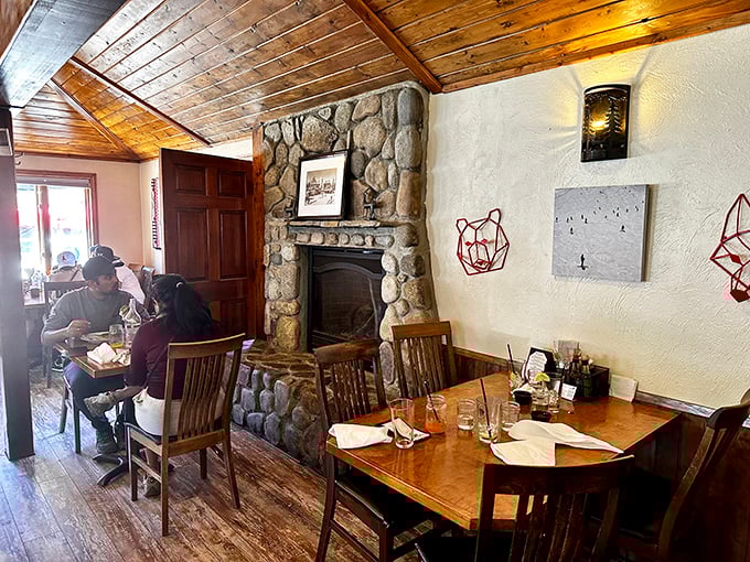That stone fireplace isn't just for show—it's the heart of a dining room where memories are made between bites of exceptional food.