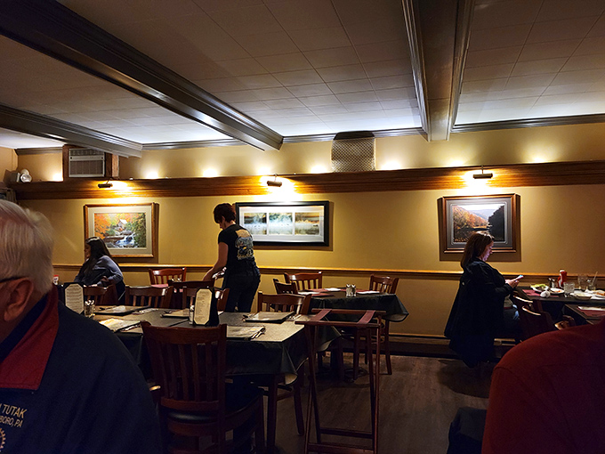 Warm lighting, landscape paintings, and wooden chairs create the dining equivalent of a comfortable sweater on a cool evening.